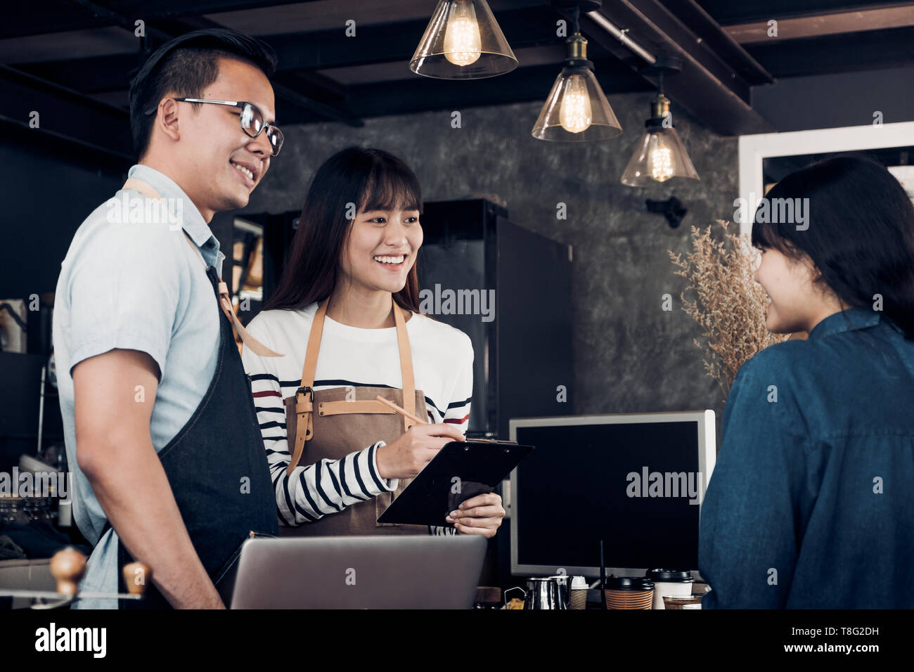 Asia barista waiter and waitress take order from customer in coffee ...