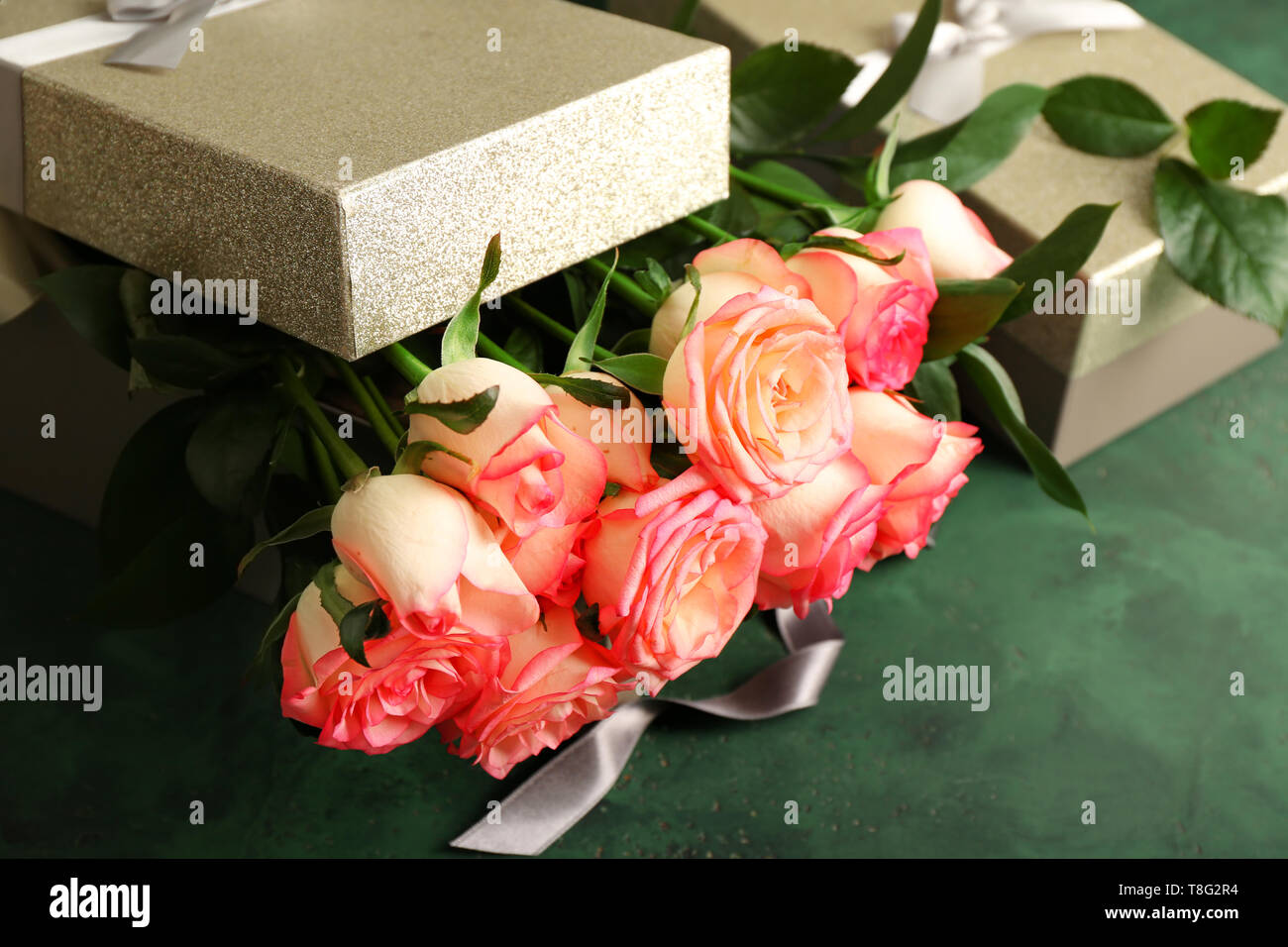 Gift box with beautiful roses on color table Stock Photo - Alamy