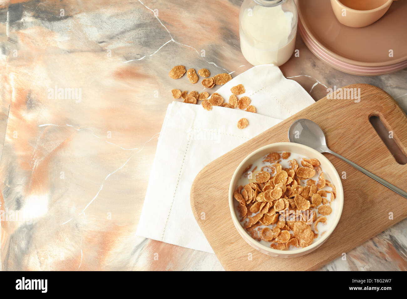 Bowl with healthy cornflakes and milk on color table Stock Photo - Alamy