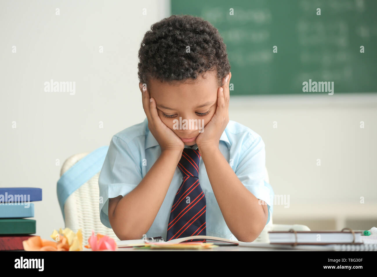 Bored African-American boy unwilling to study in classroom Stock Photo ...