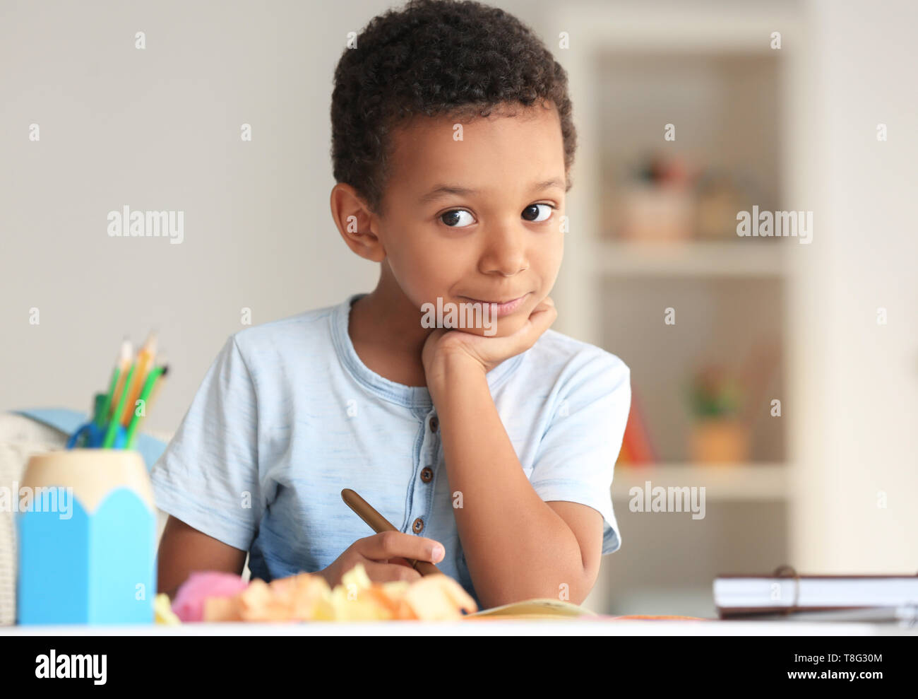 Cute African-American boy doing homework in classroom Stock Photo - Alamy