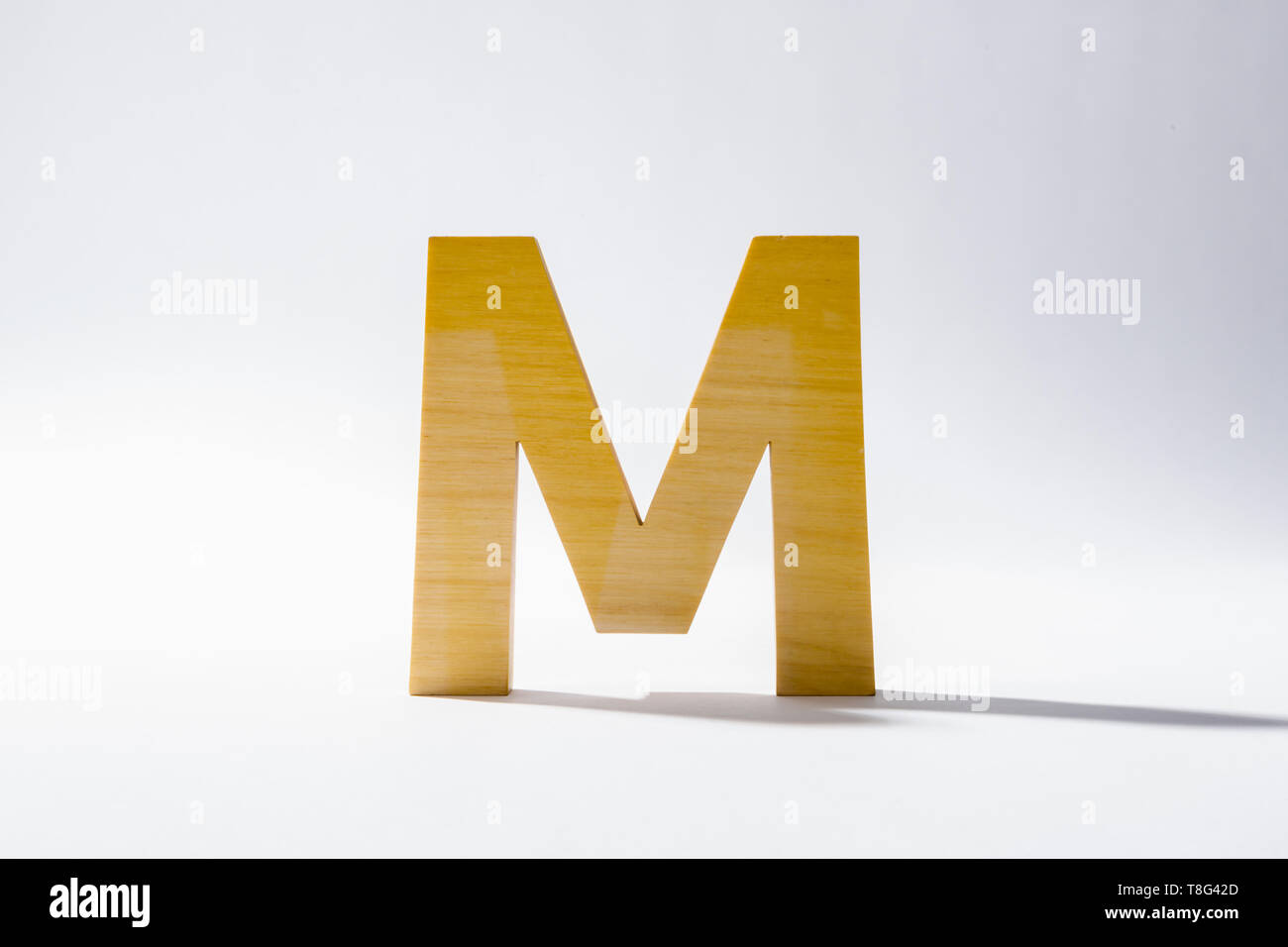 Wooden Alphabet M and Shadow Reflection Stock Photo - Alamy
