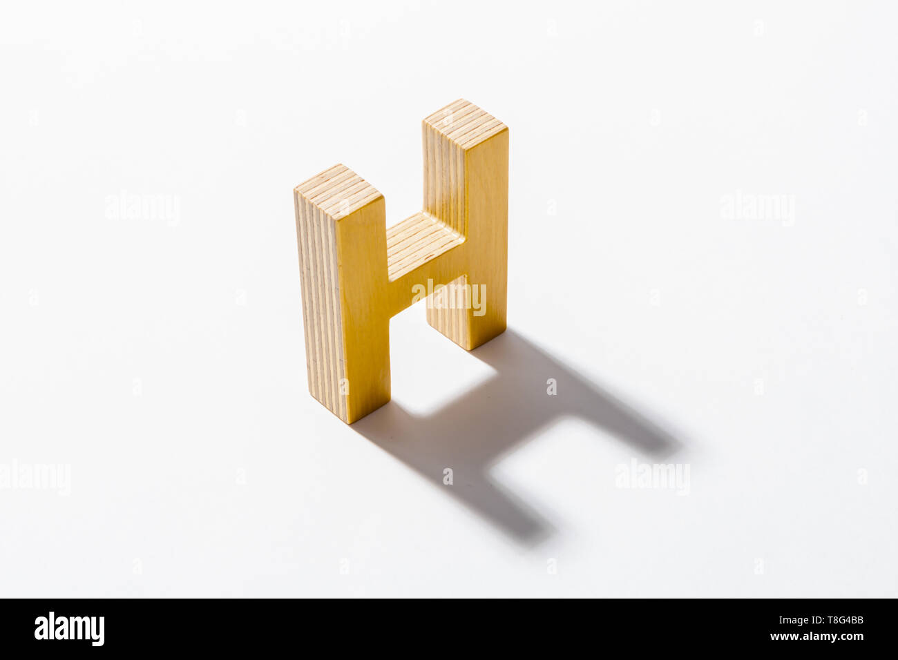 Wooden Alphabet H and Shadow Reflection Stock Photo - Alamy