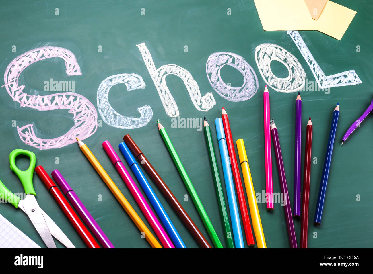 Set of stationery and word SCHOOL written on chalkboard Stock Photo - Alamy