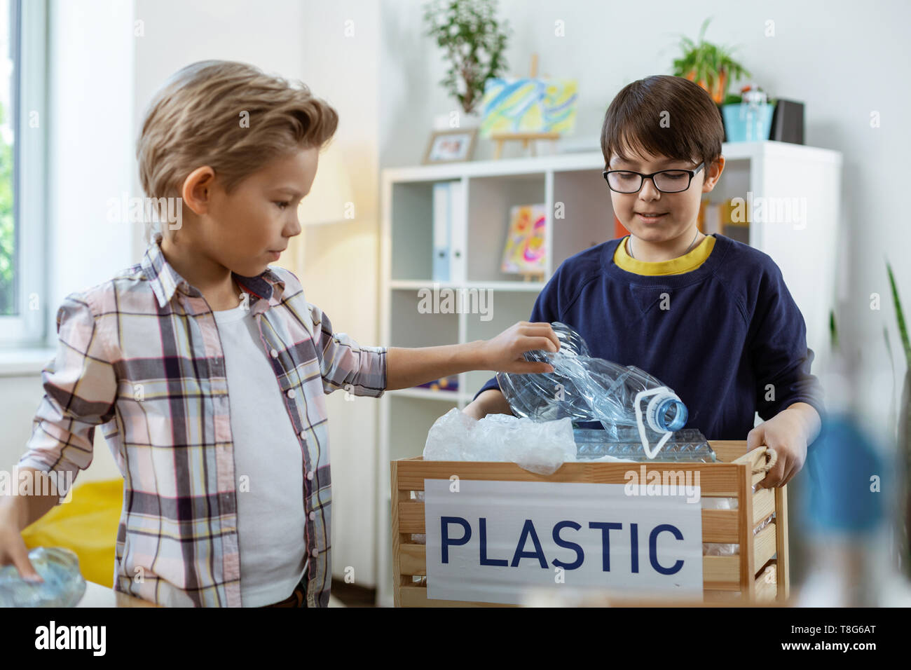 Hard-working little boys filling trash bean with plastic trash Stock ...