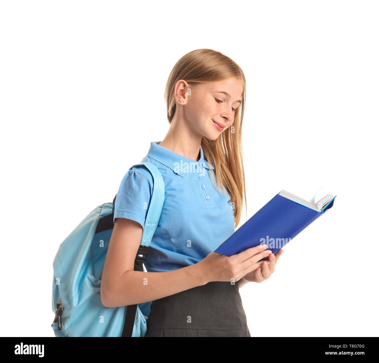 Cute schoolgirl reading book against white background Stock Photo - Alamy