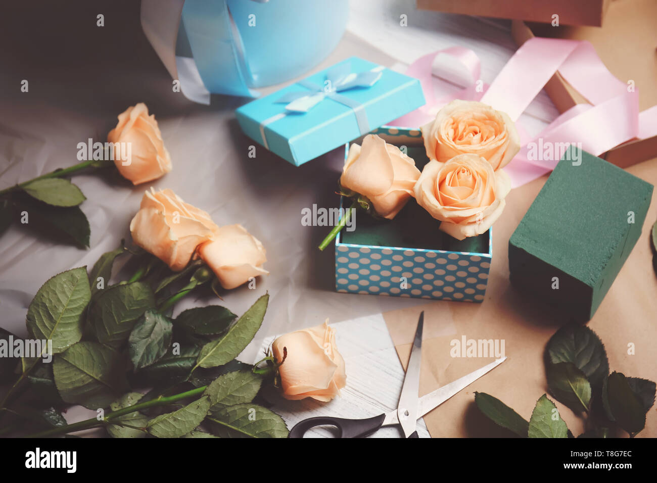 Gift box with beautiful flowers on table of florist Stock Photo - Alamy