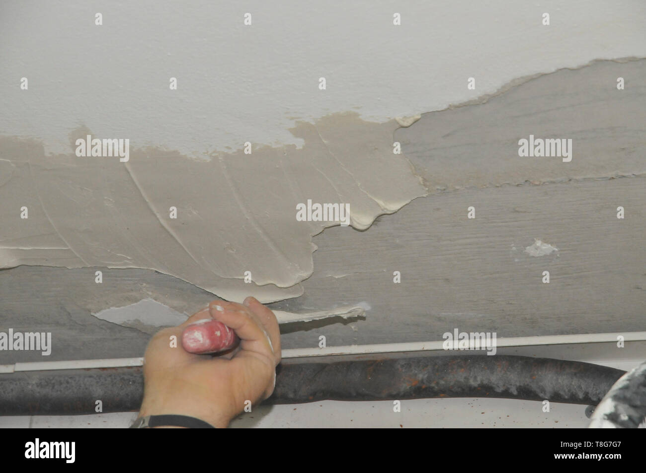 Home care. a room is being re plastered using a Putty knife. The ...