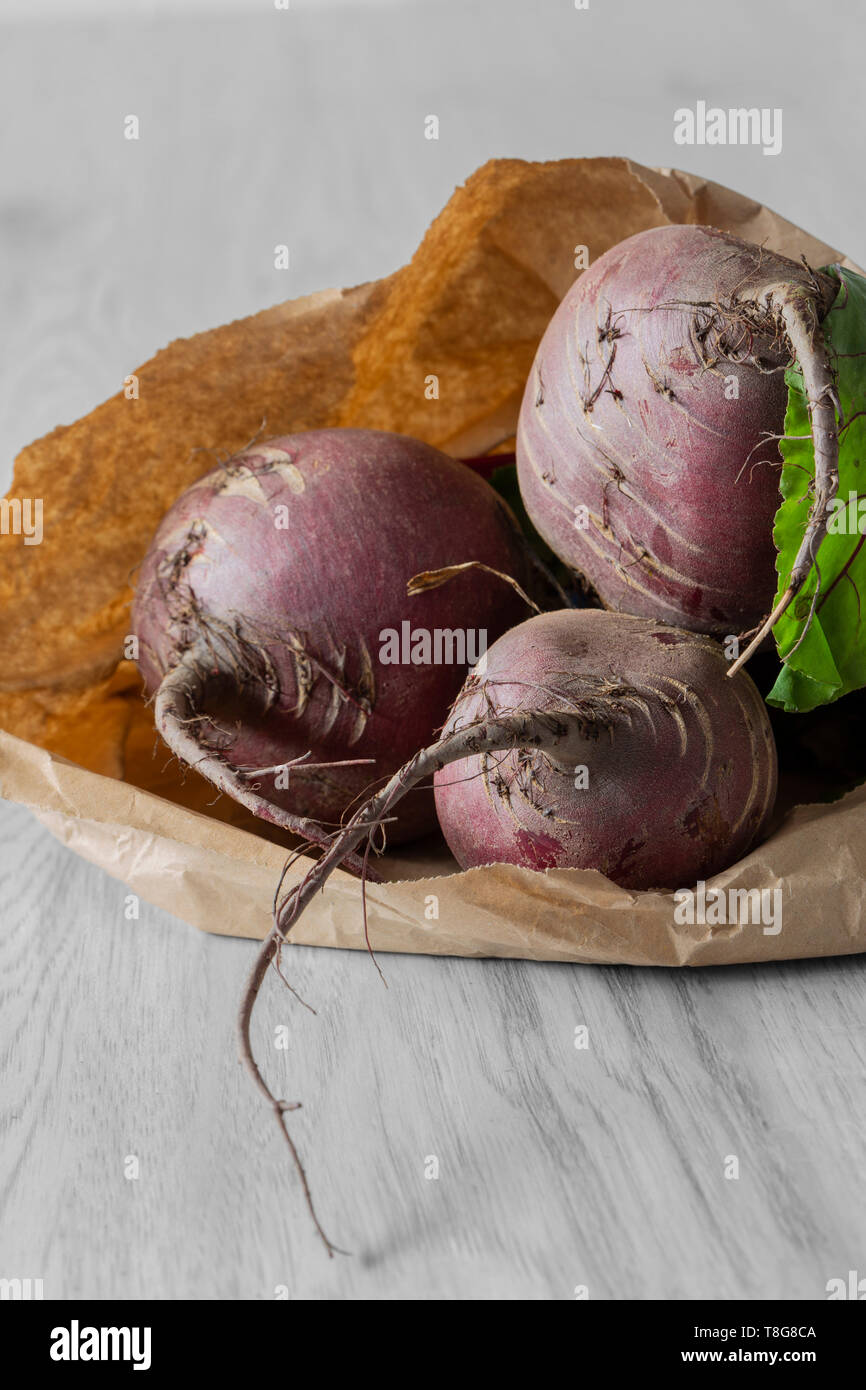 Organic beetroot in a brown paper bag on grey wood. Recycle packaging ...