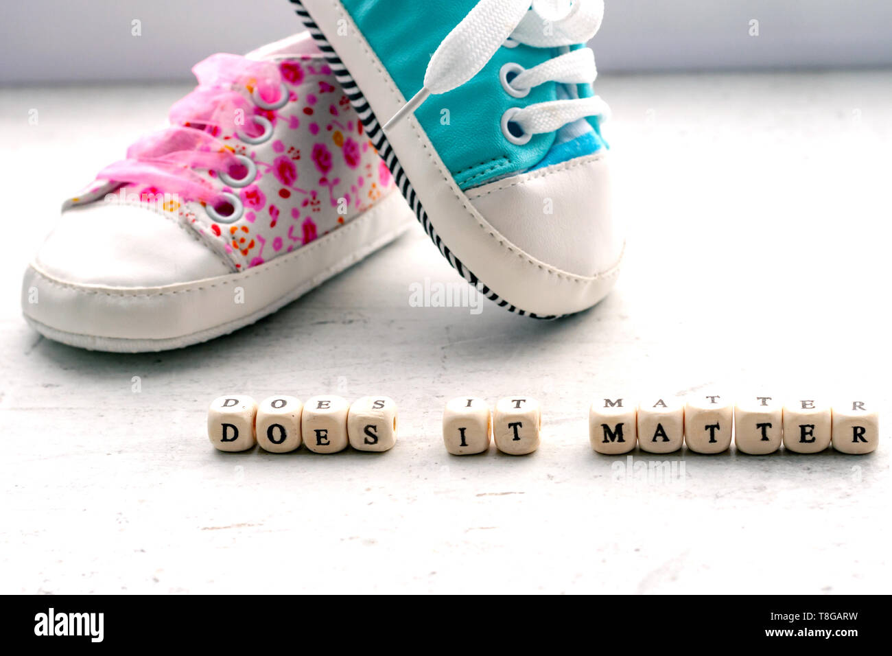 Pink and blue baby booties on a light background. Inscription does it ...