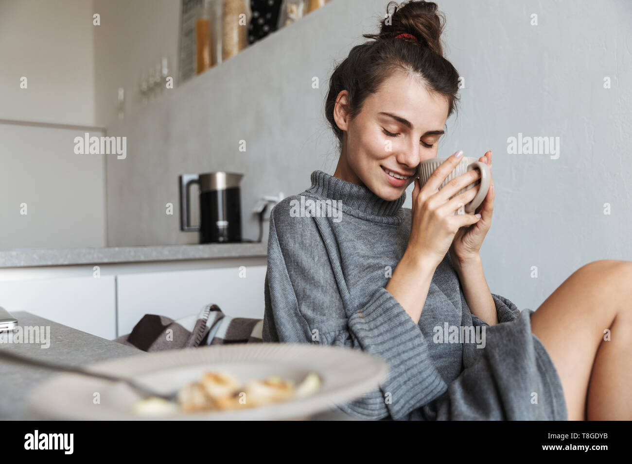 Beautiful young woman having healthy breakfast while sitting on a ...