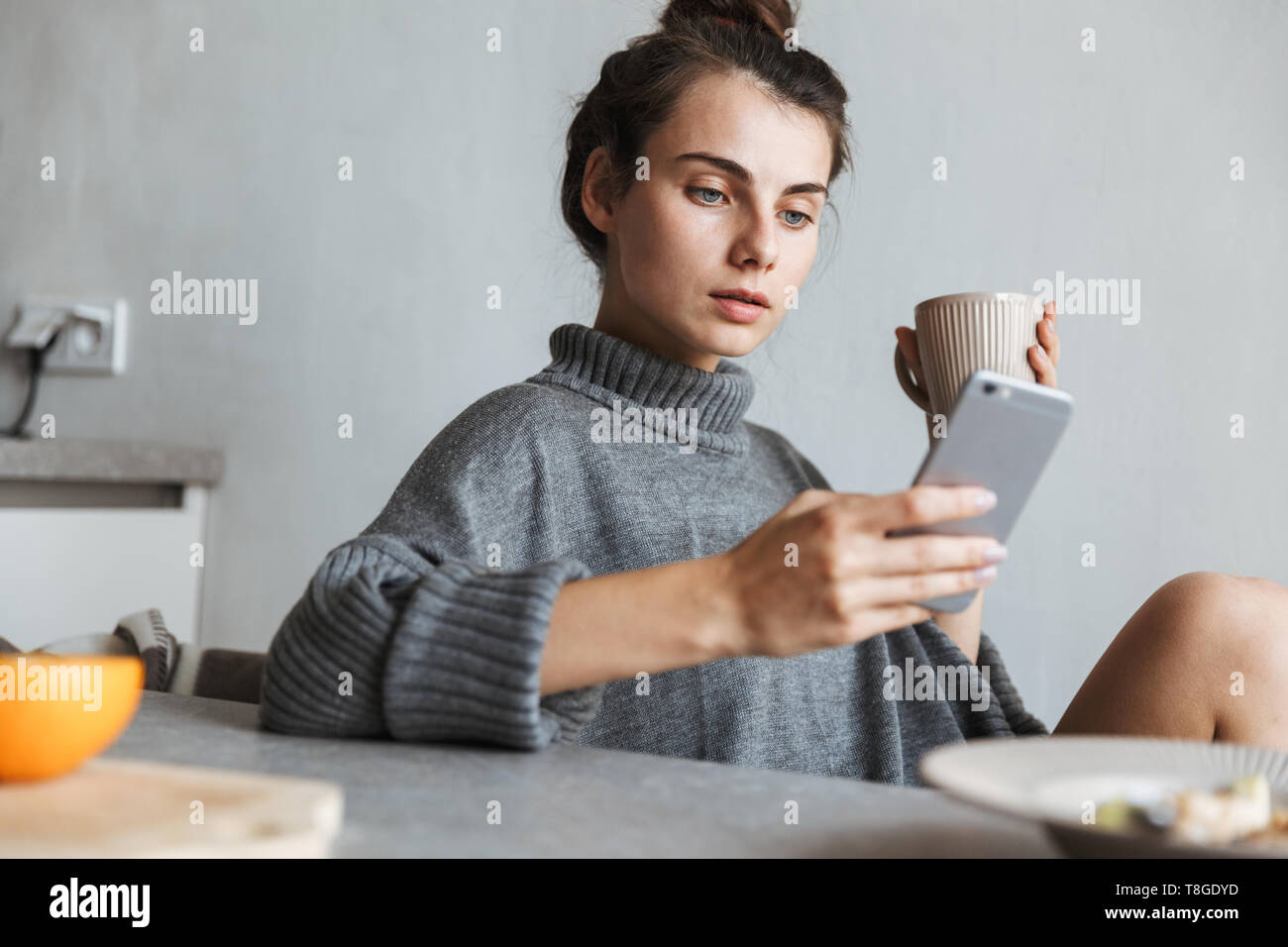Beautiful young woman having healthy breakfast while sitting on a ...