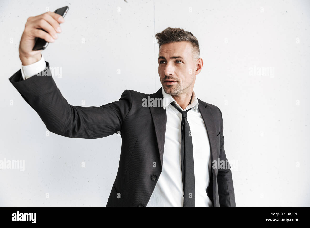 Handsome confident businessman wearing formal clothes standing isolated ...