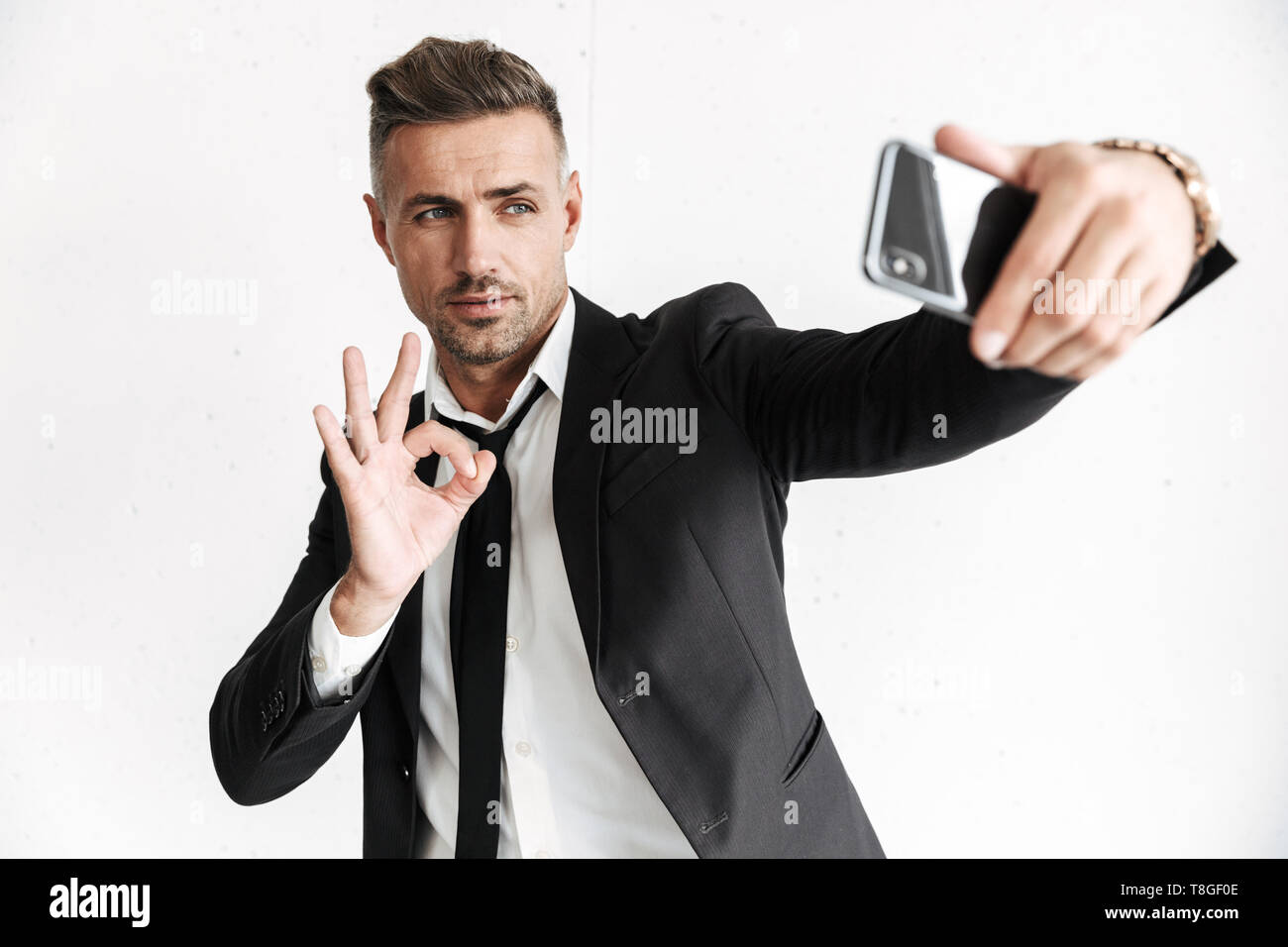 Handsome confident businessman wearing formal clothes standing isolated ...