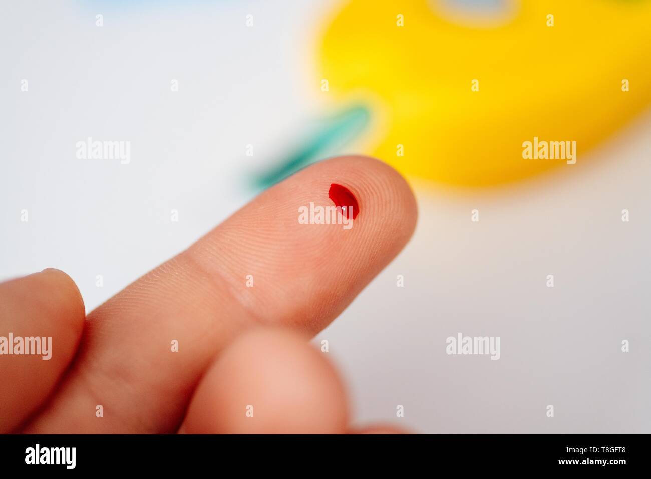 Drop of blood on finger. Man doing glucose blood test with lancet hand ...