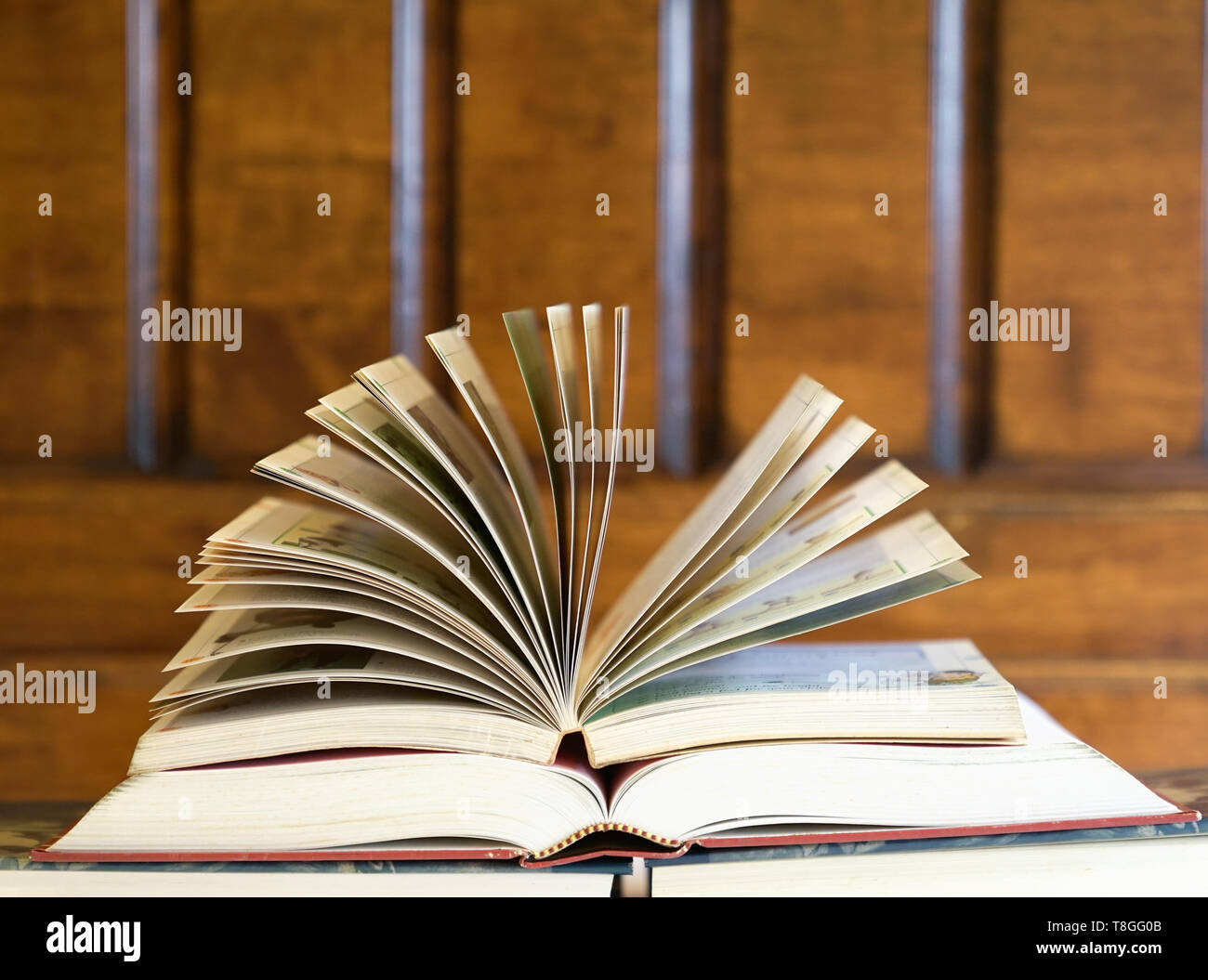 Open textbook on top of books with wood background, an education ...
