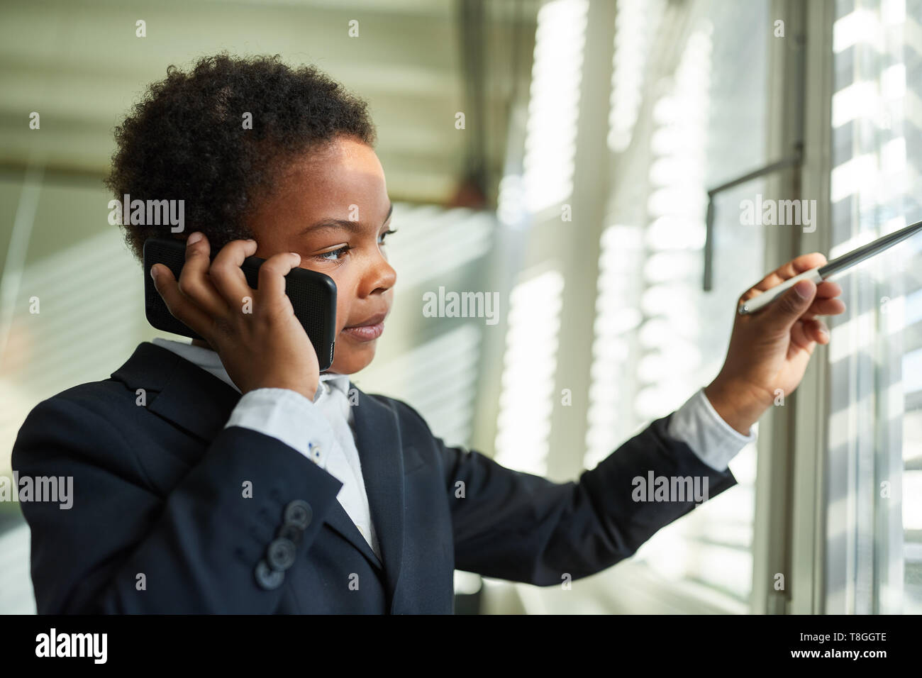 African child talking on the phone disguised as a manager or consultant ...