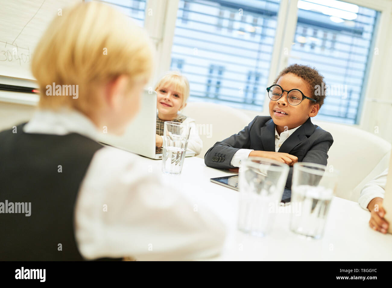 Children as business people in a meeting negotiating a multicultural ...