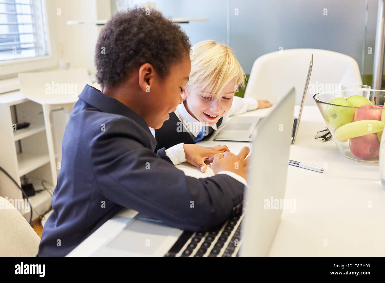 Two boys as students or business people learn together in computer ...