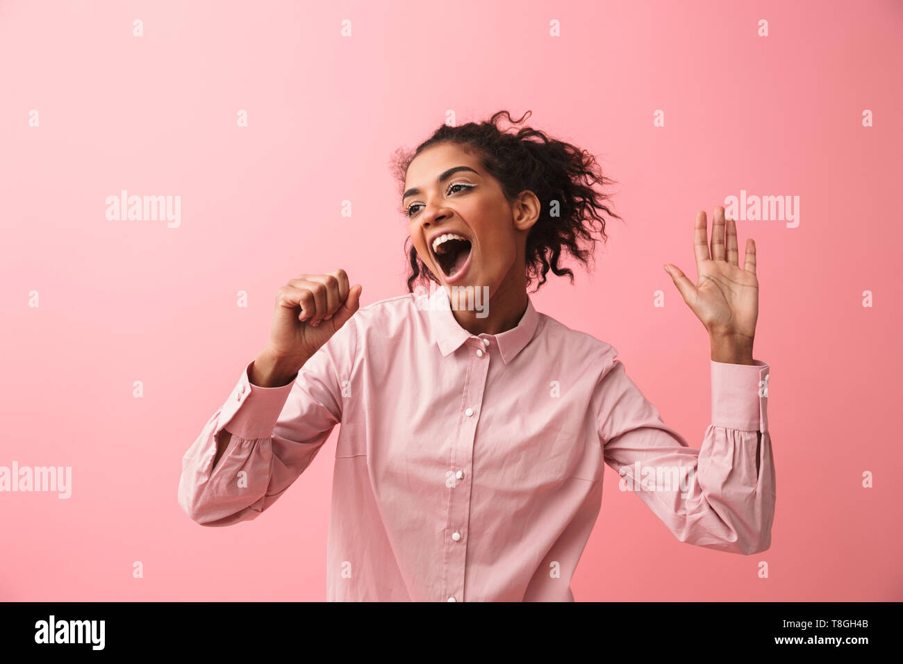 Image of a beautiful young african woman posing isolated over pink wall ...