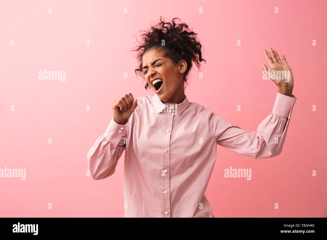 Image of a beautiful young african woman posing isolated over pink wall ...