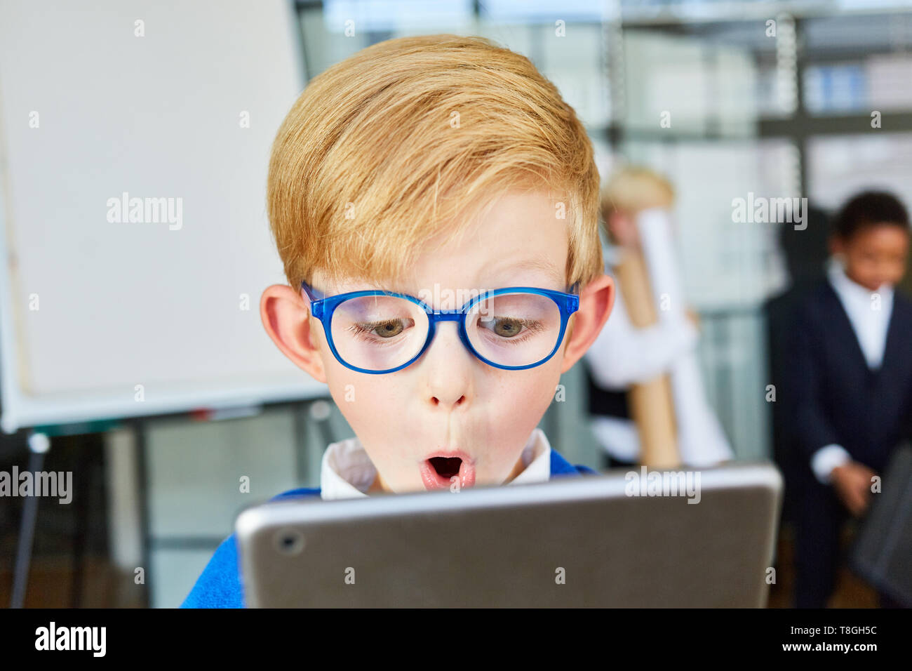 Child looks with surprise on computer monitor with social media message ...