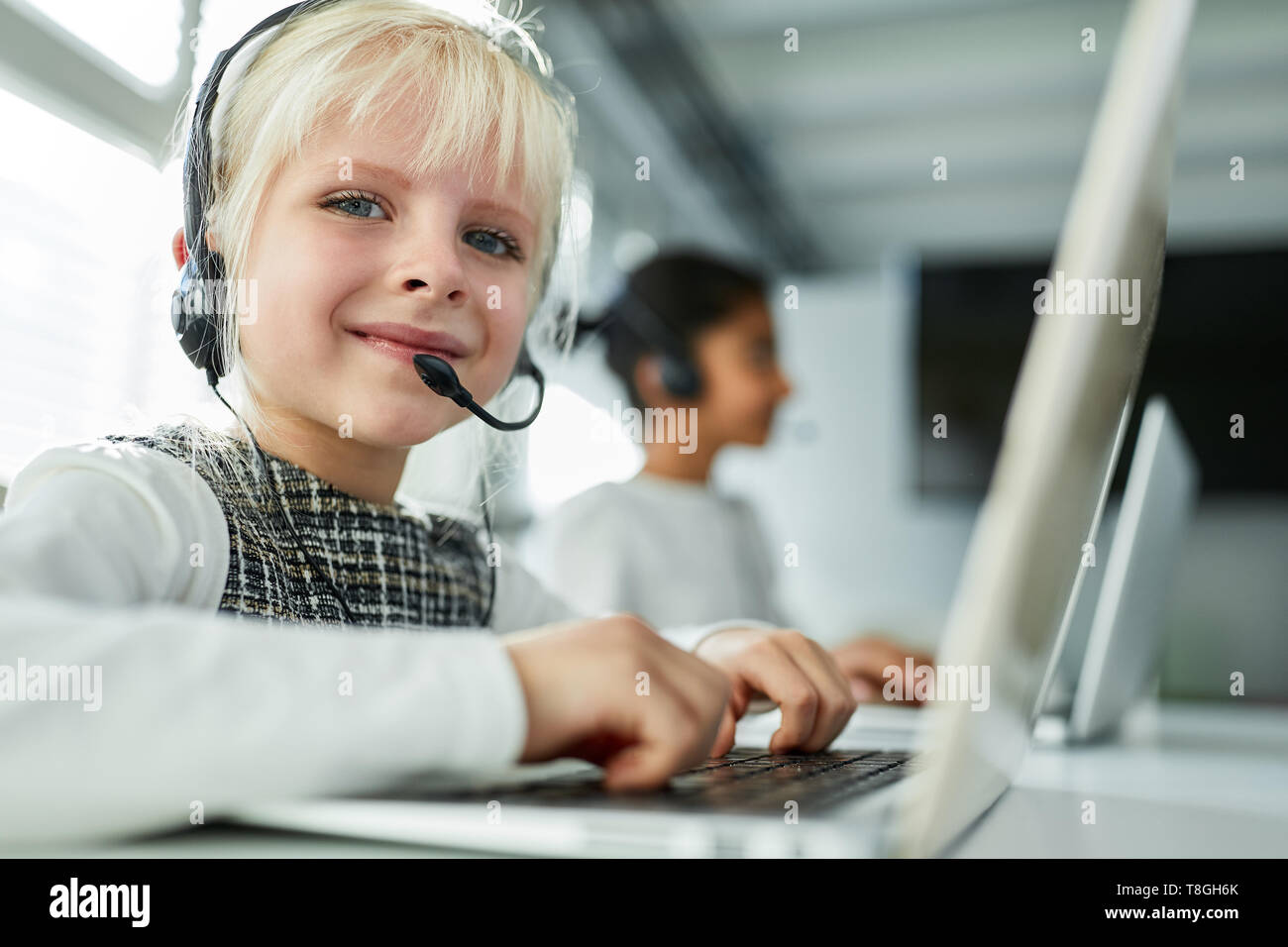 Girl as a student at the computer with headset in a language course at ...