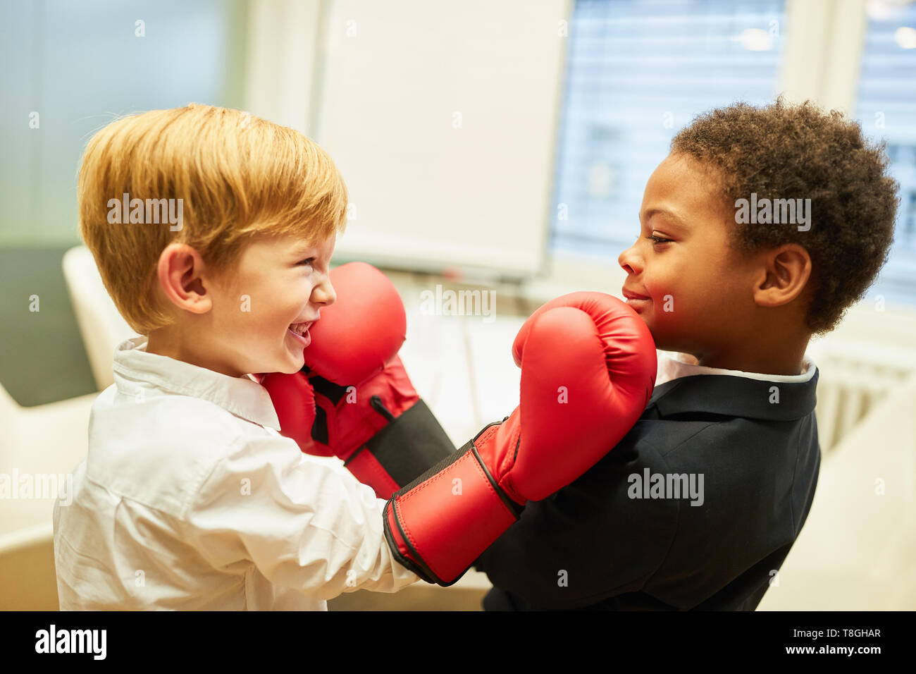 Two boys as business people with boxing gloves measure their strength ...