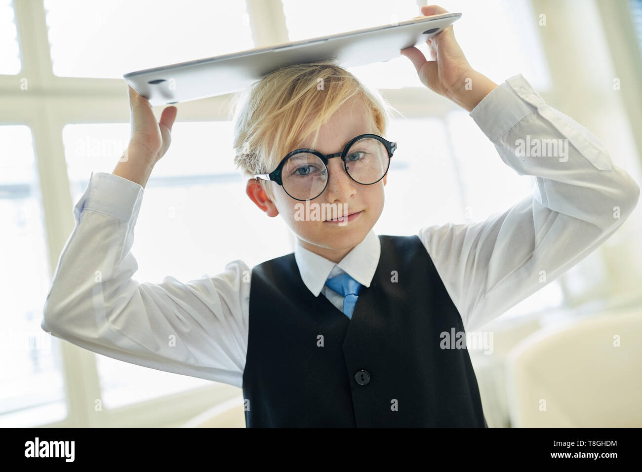 Child as a businessman or software developer balances laptop on his ...
