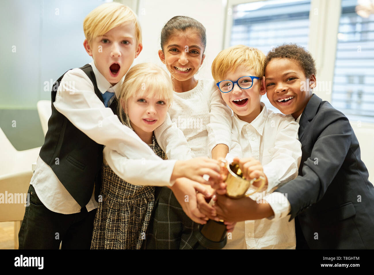 Successful start-up team wins a cup and enthusiastically celebrates the ...