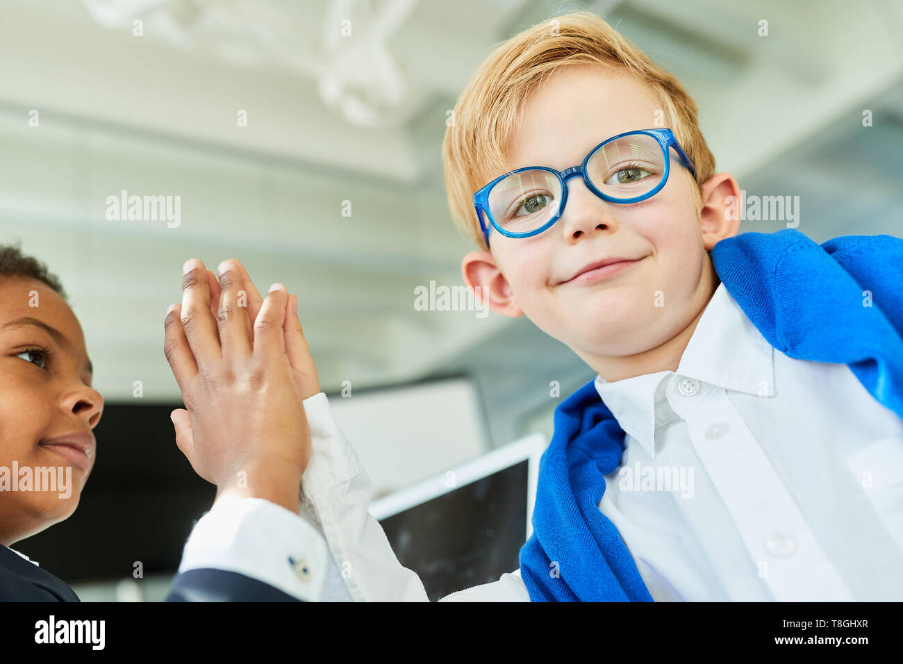 Two multicultural children enter a high five for international ...