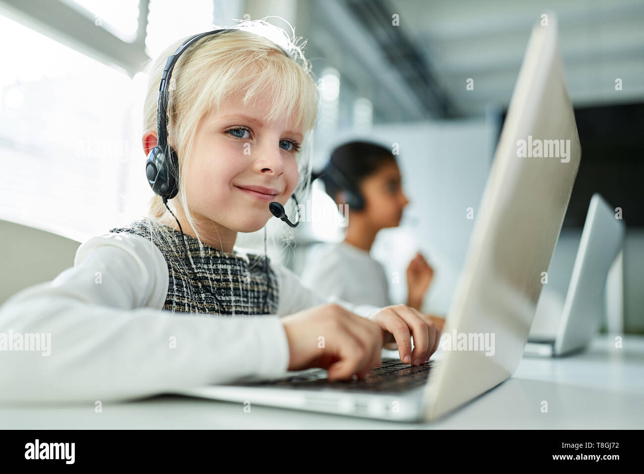 Children with headset on laptop Computer as a call center Employee in ...
