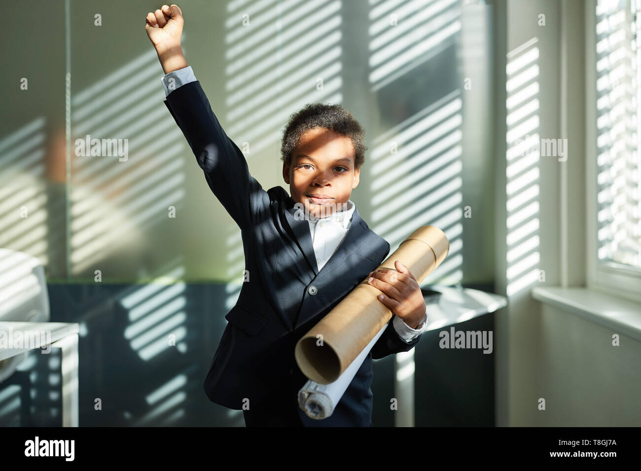 African boy as a successful architect with architectural drawing while ...