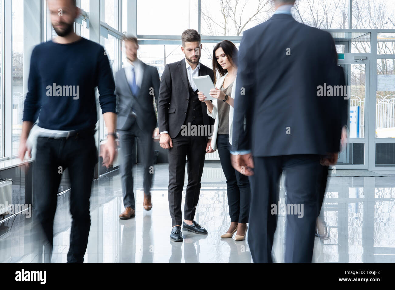 White collar workers going down office corridor during working day ...