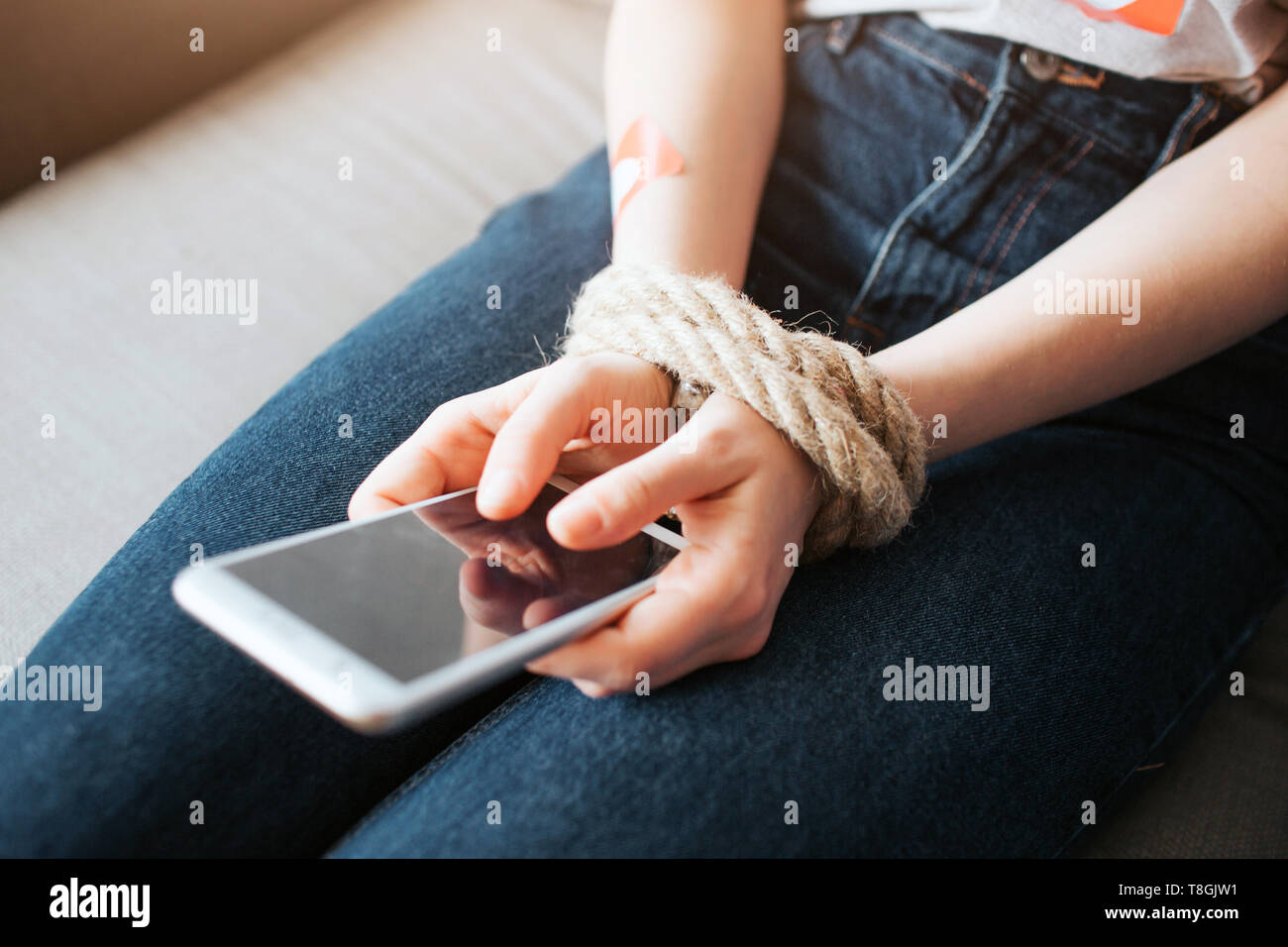 Young woman have social media addiction. Sitting on sofa. Phone in ...