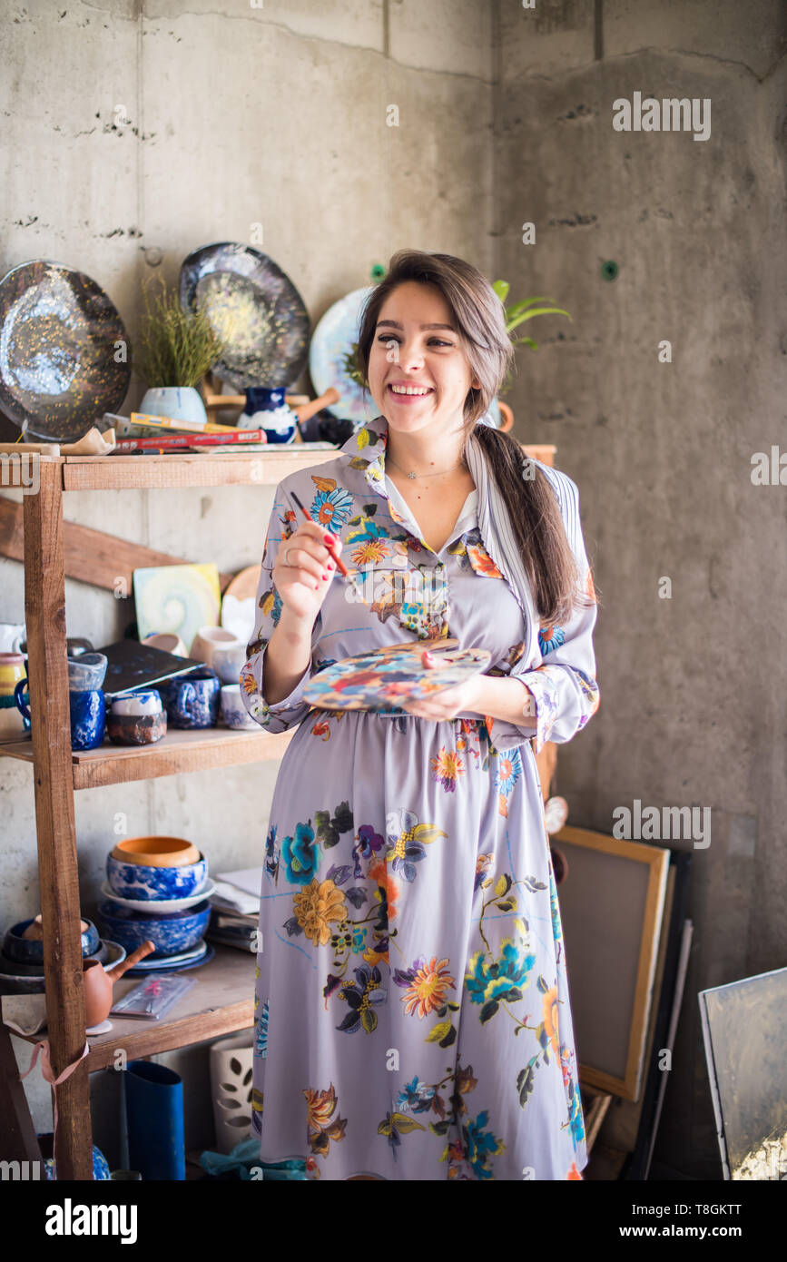 Beautiful lady artist standing in her studio, creative business owner ...