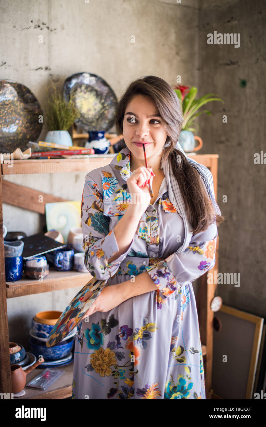 Beautiful lady artist standing in her studio, creative business owner ...