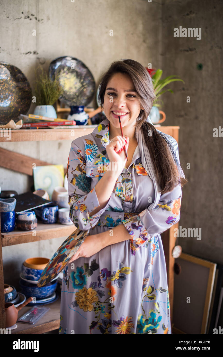 Beautiful lady artist standing in her studio, creative business owner ...