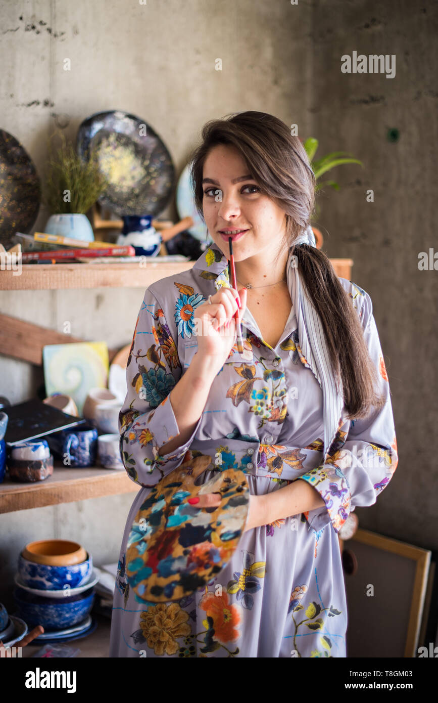 Beautiful lady artist standing in her studio, creative business owner ...