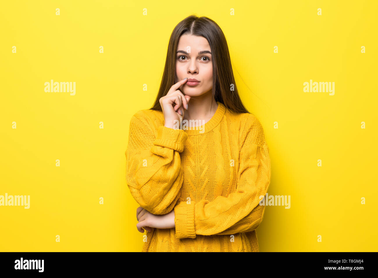 Young woman thinking wearing in yellow sweater isolated on yellow ...