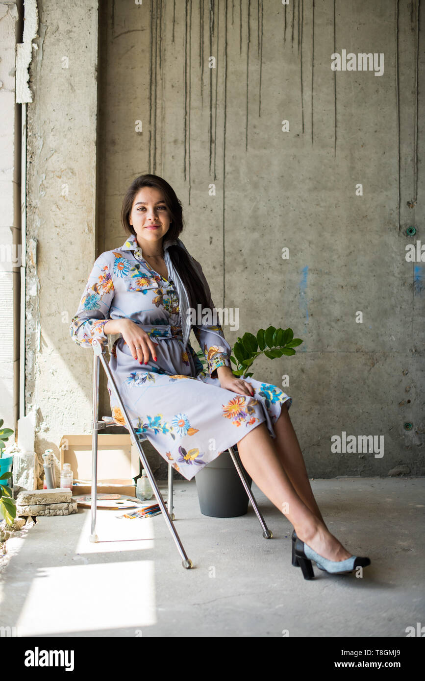 Beautiful young lady artist sitting in her bohemian artistic studio ...