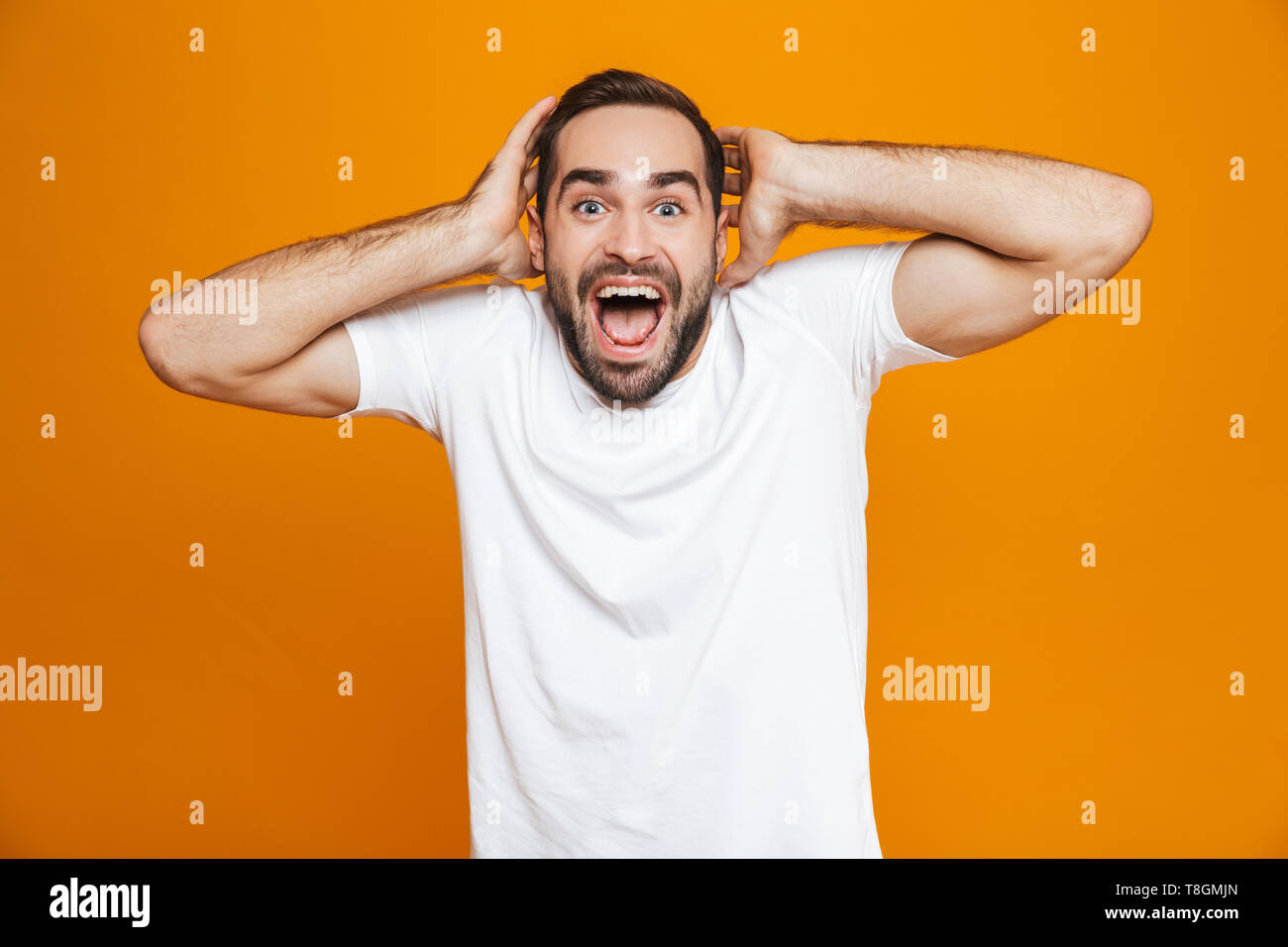 Image of joyful man 30s with beard and mustache grabbing head while ...