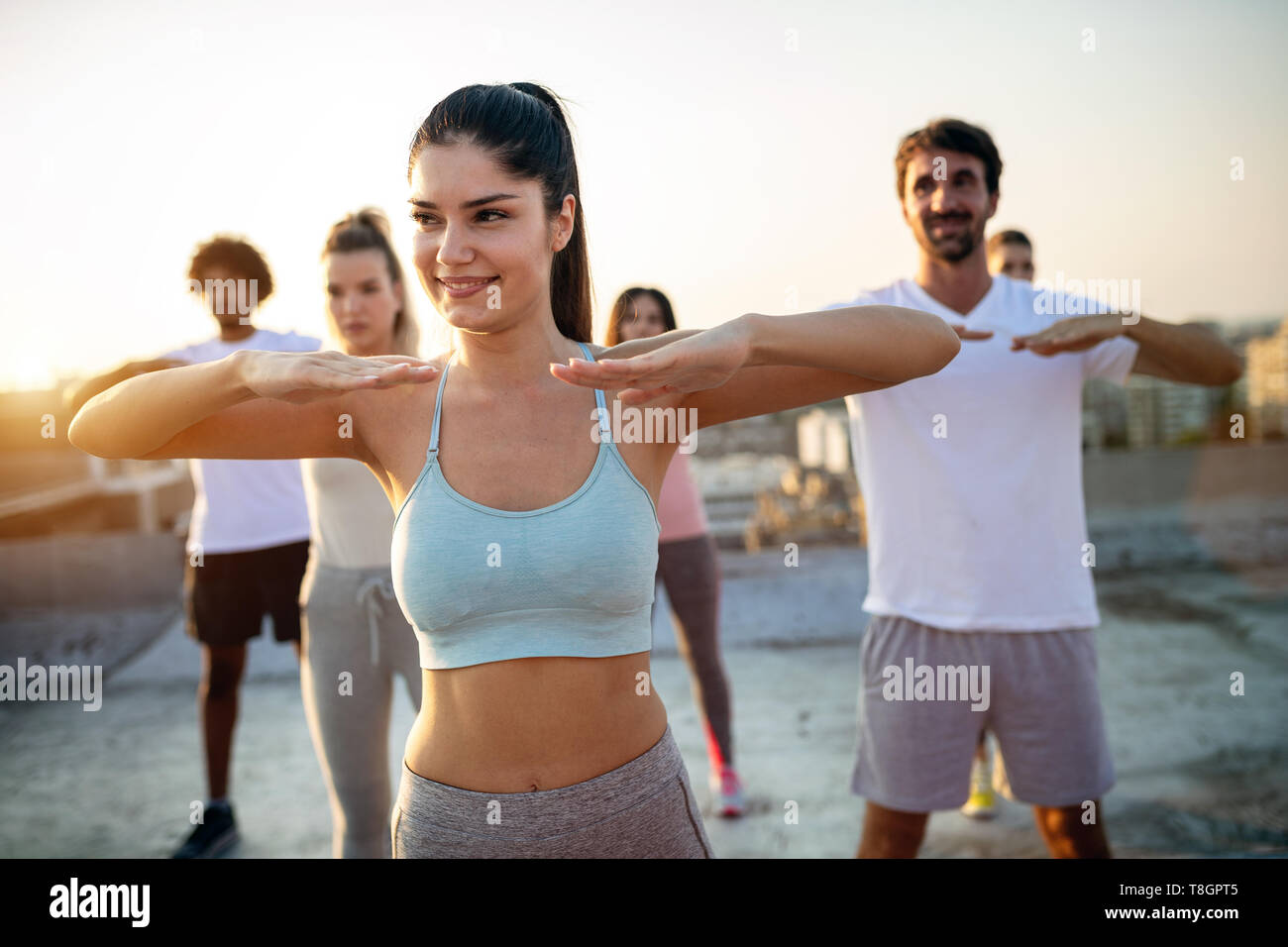 Group of fit healthy friends, people exercising together outdoor on ...