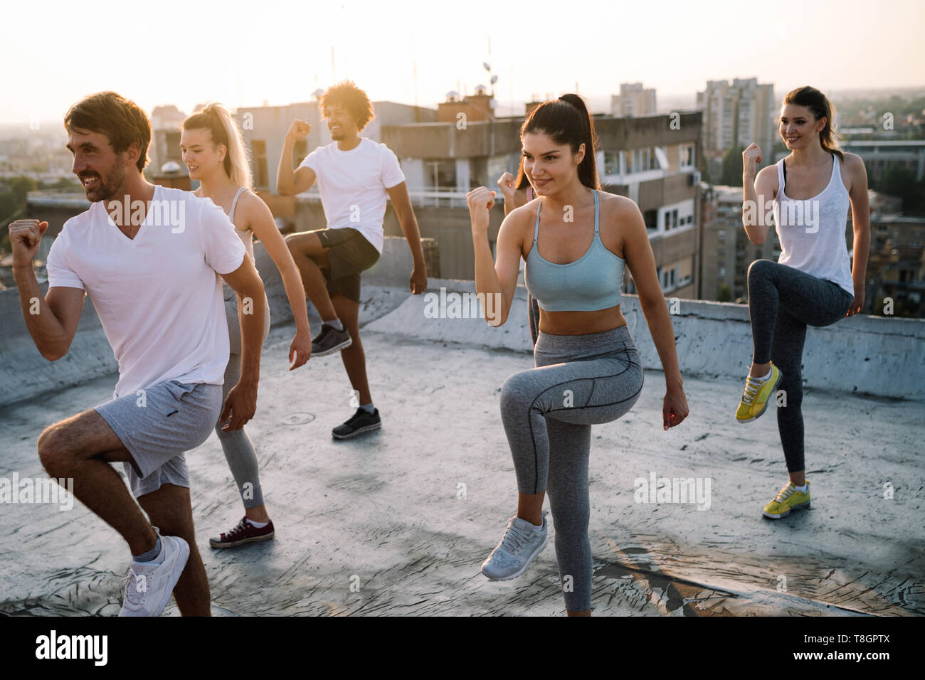 Group of fit healthy friends, people exercising together outdoor on ...