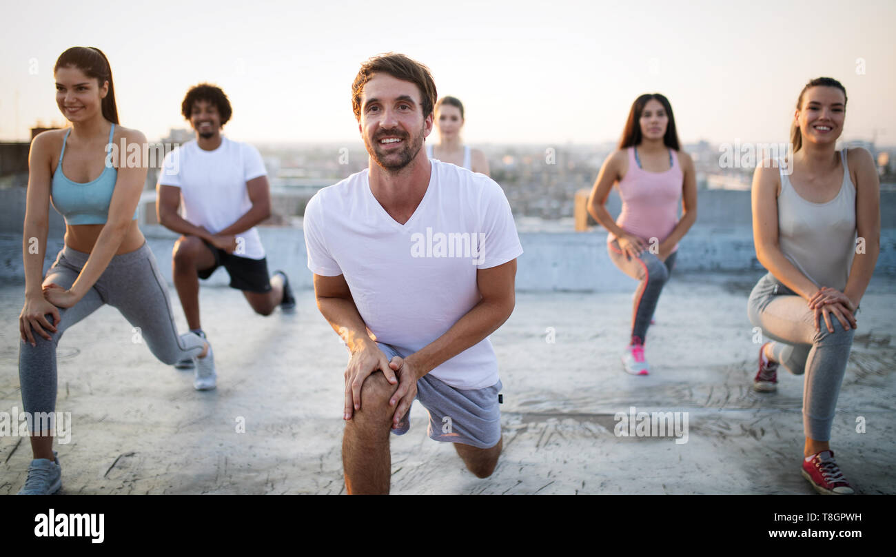 Group of fit healthy friends, people exercising together outdoor on ...