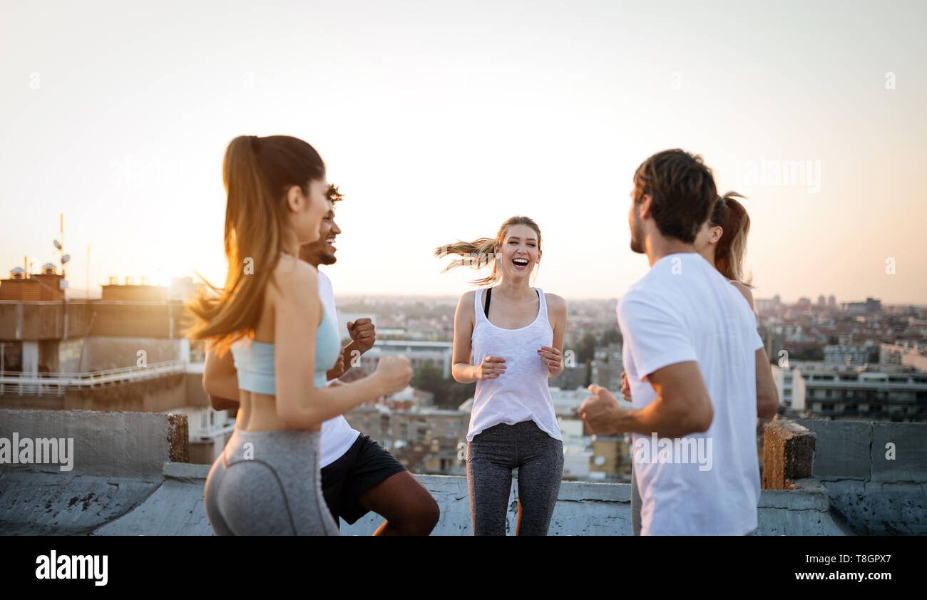 Group of fit healthy friends, people exercising together outdoor on ...