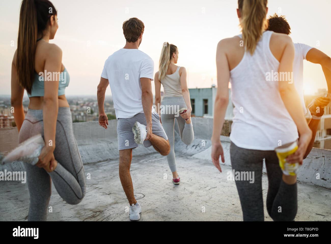 Group of fit healthy friends, people exercising together outdoor on ...