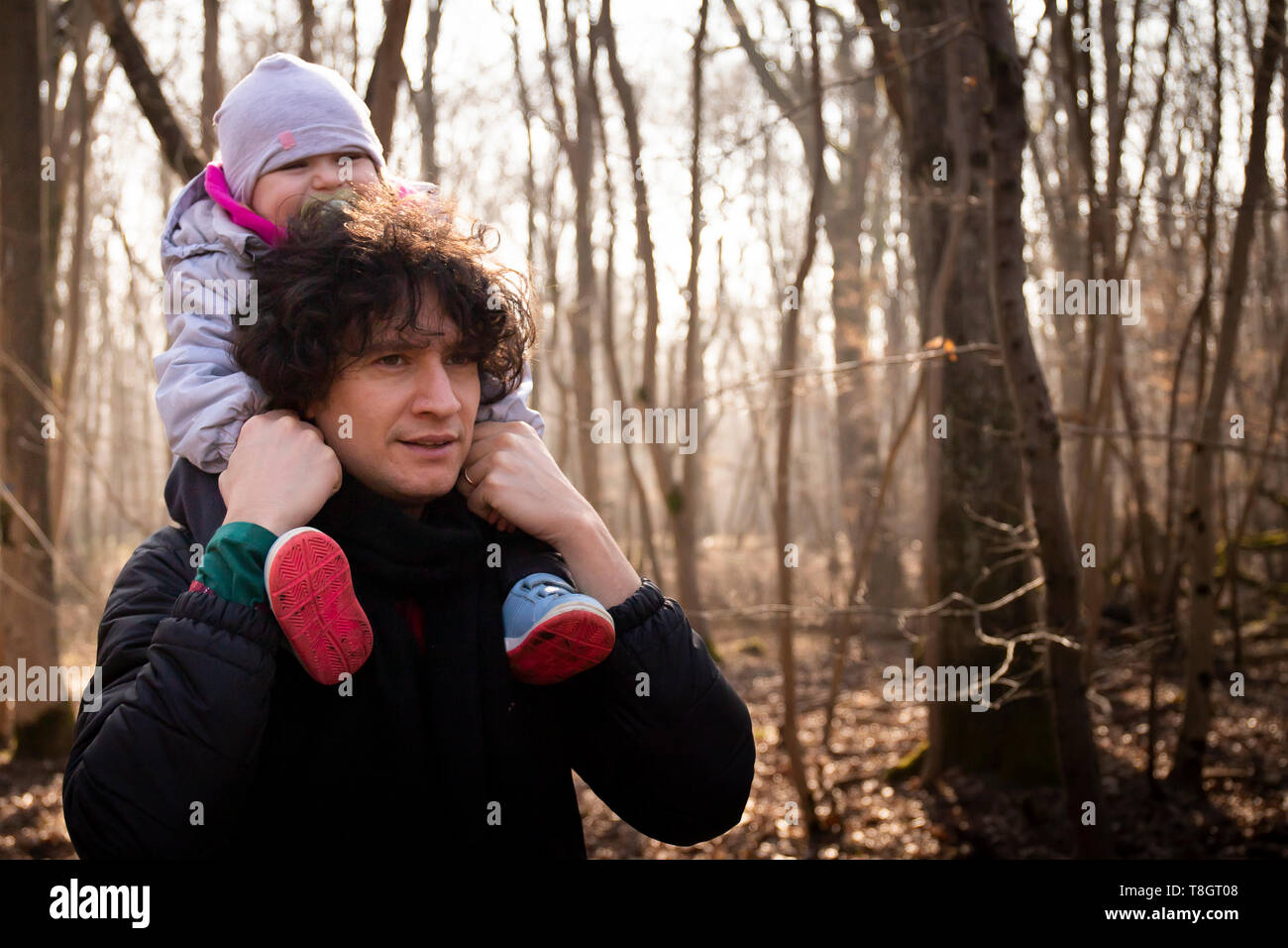 Young dad carrying baby on his shoulders in a forest at sunset Stock ...