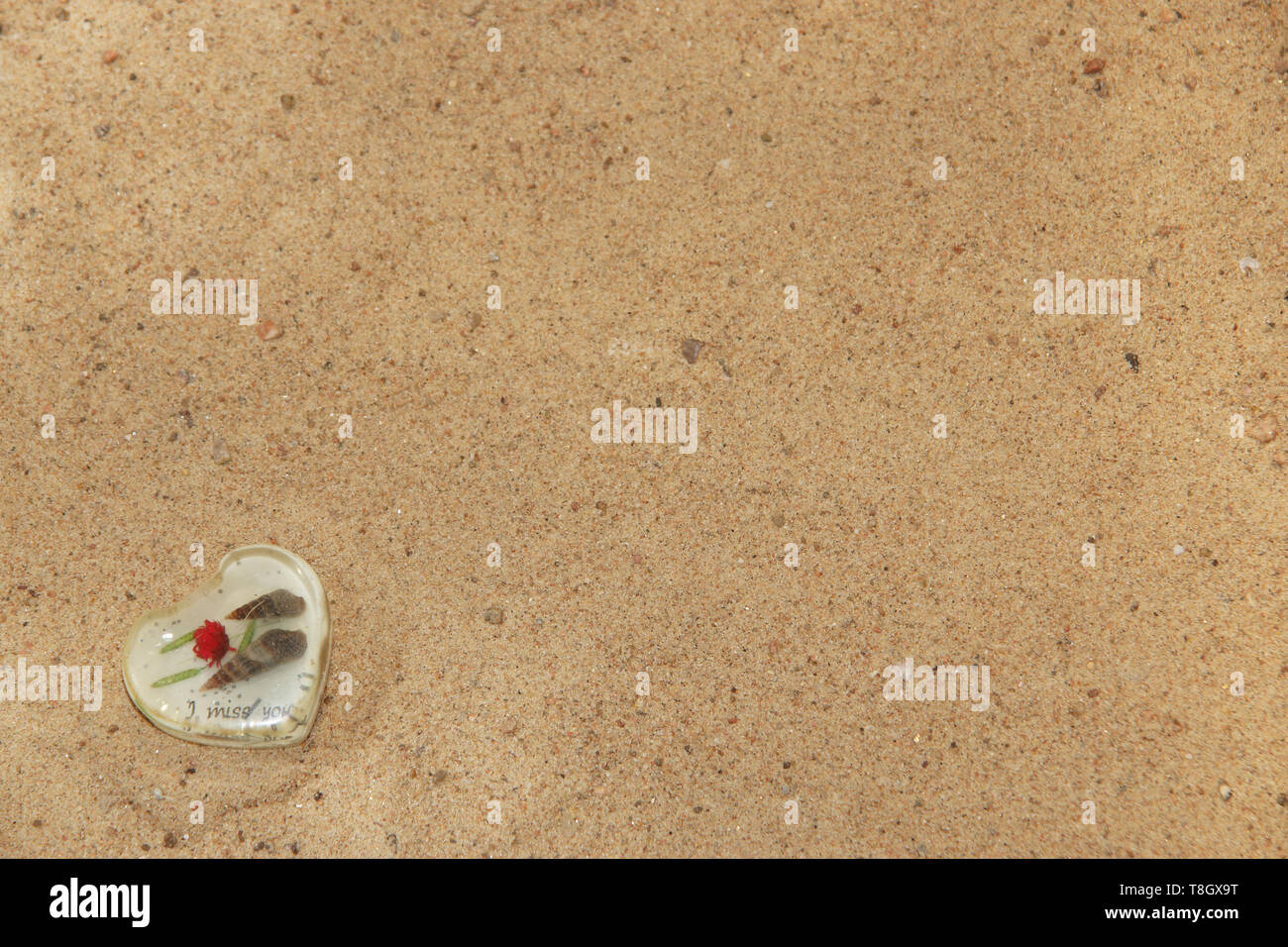 Plastic heart on the sand in the lower left corner Stock Photo - Alamy