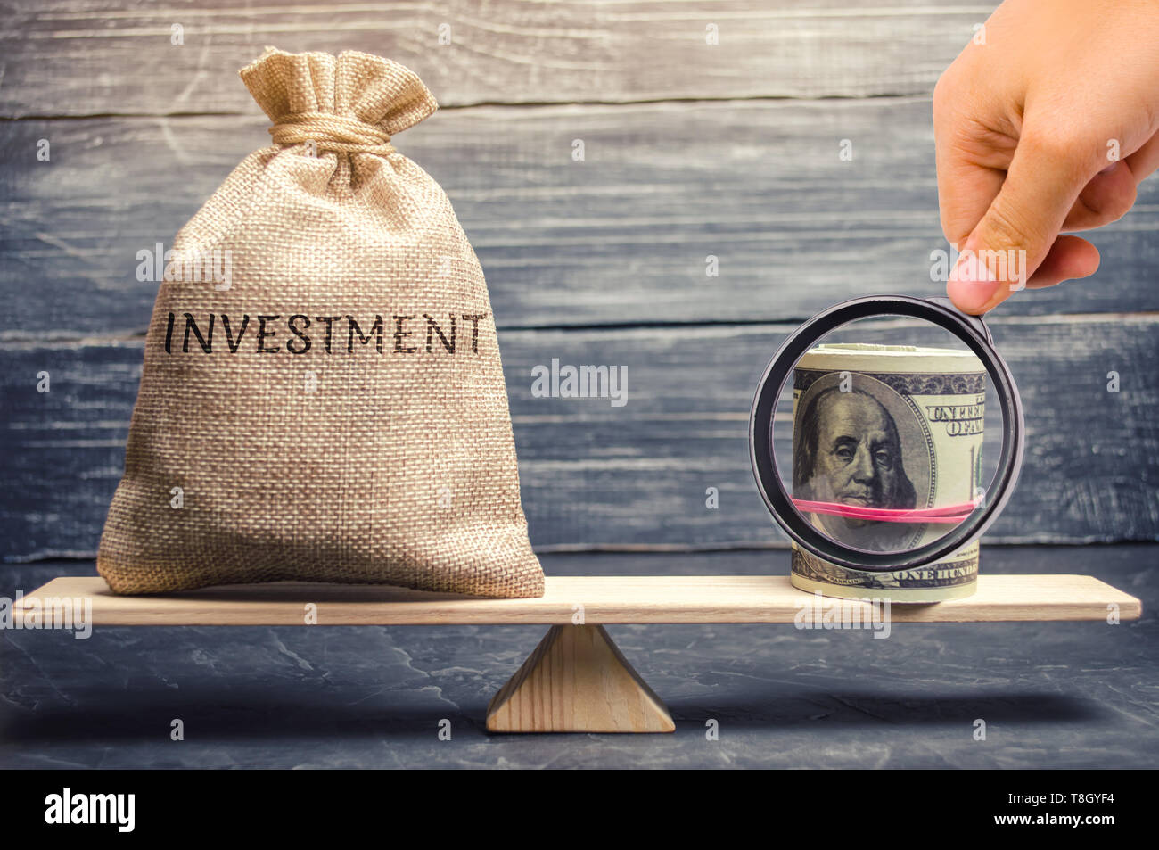 Money bag with the word Investments and dollars on scales. Attraction ...